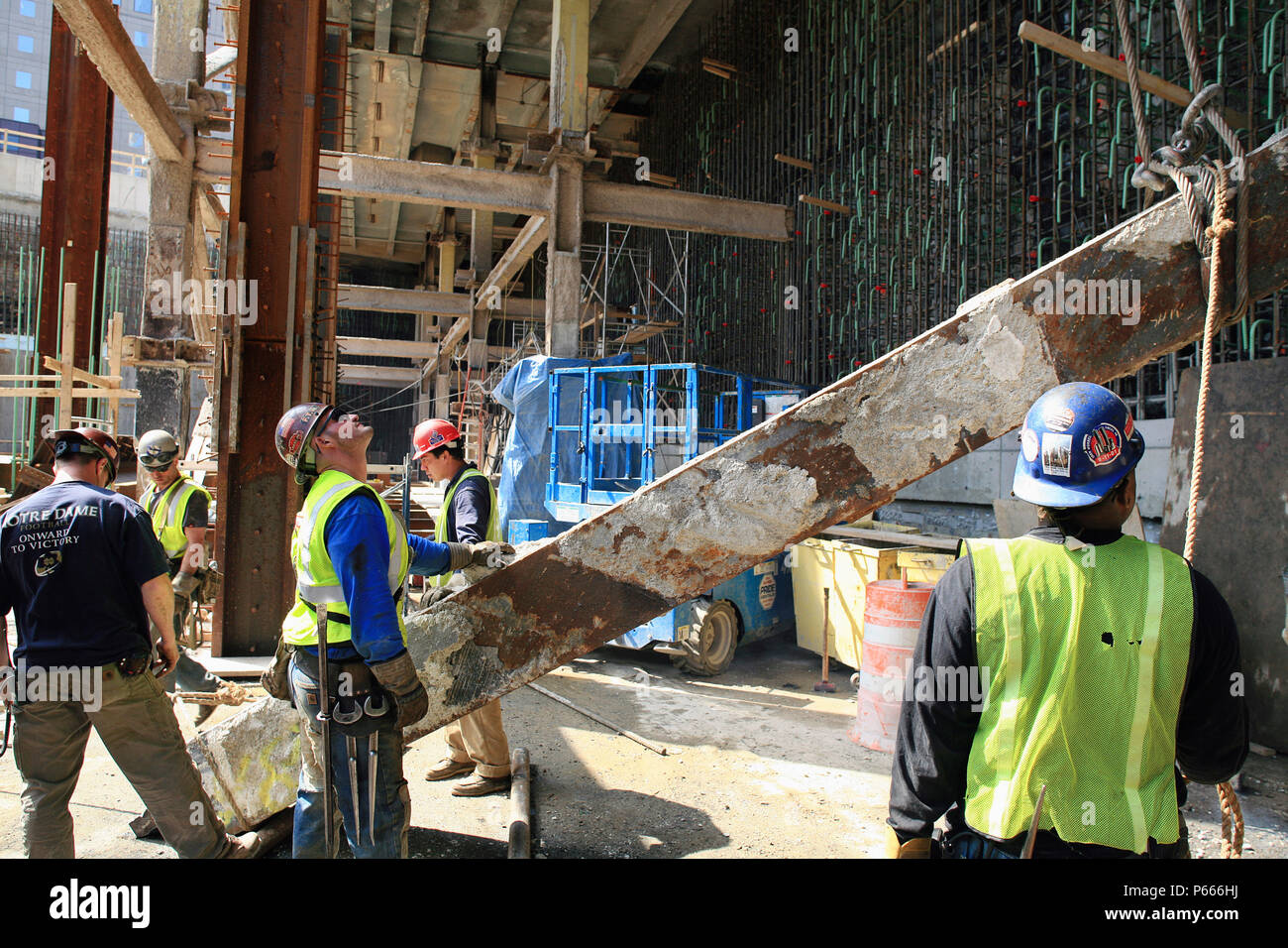 Old steel crossbeam is lowered to the ground and removed by workers at ...