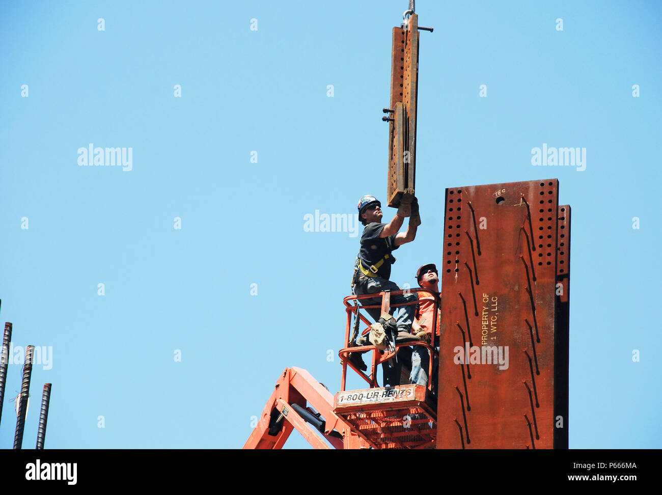 Steel workers manoeuvre a piece of steel into position at Tower One ...