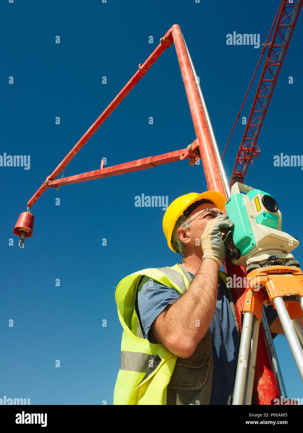 Man using theodolite on construction site, low angle Stock Photo - Alamy