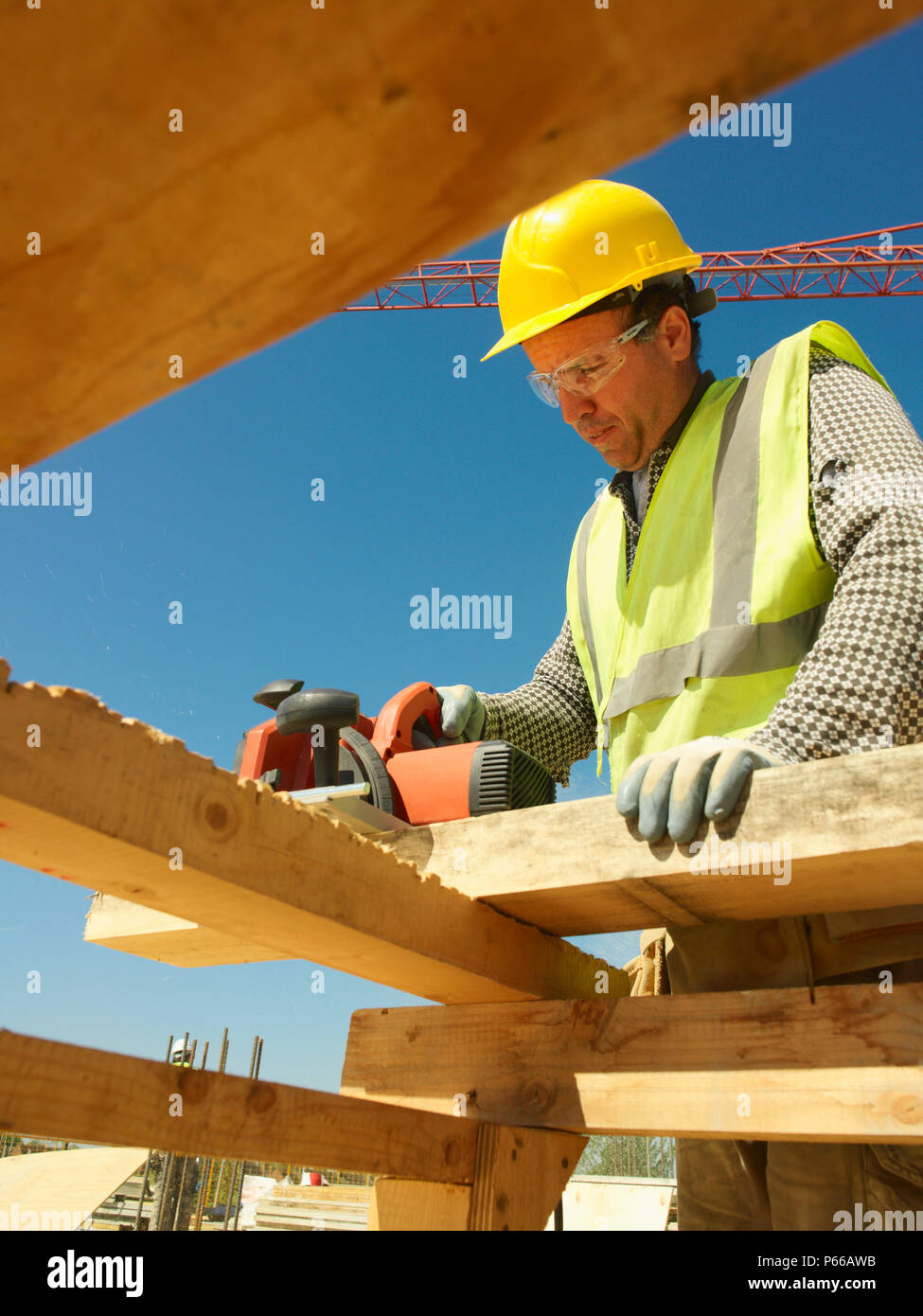 Man planing wood on construction site Stock Photo - Alamy
