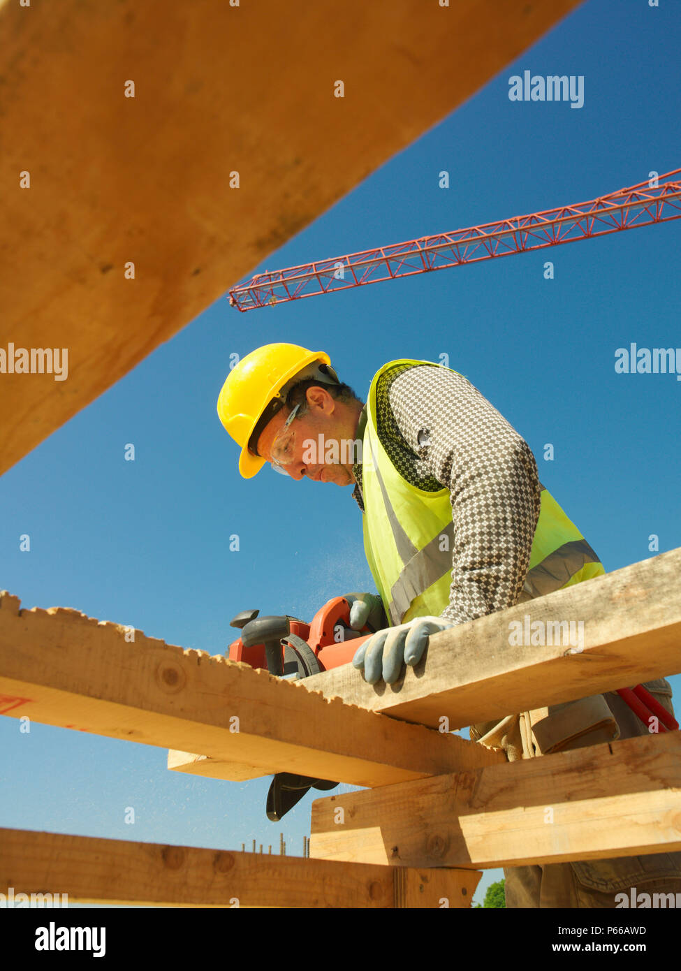 Man planing wood on construction site Stock Photo - Alamy
