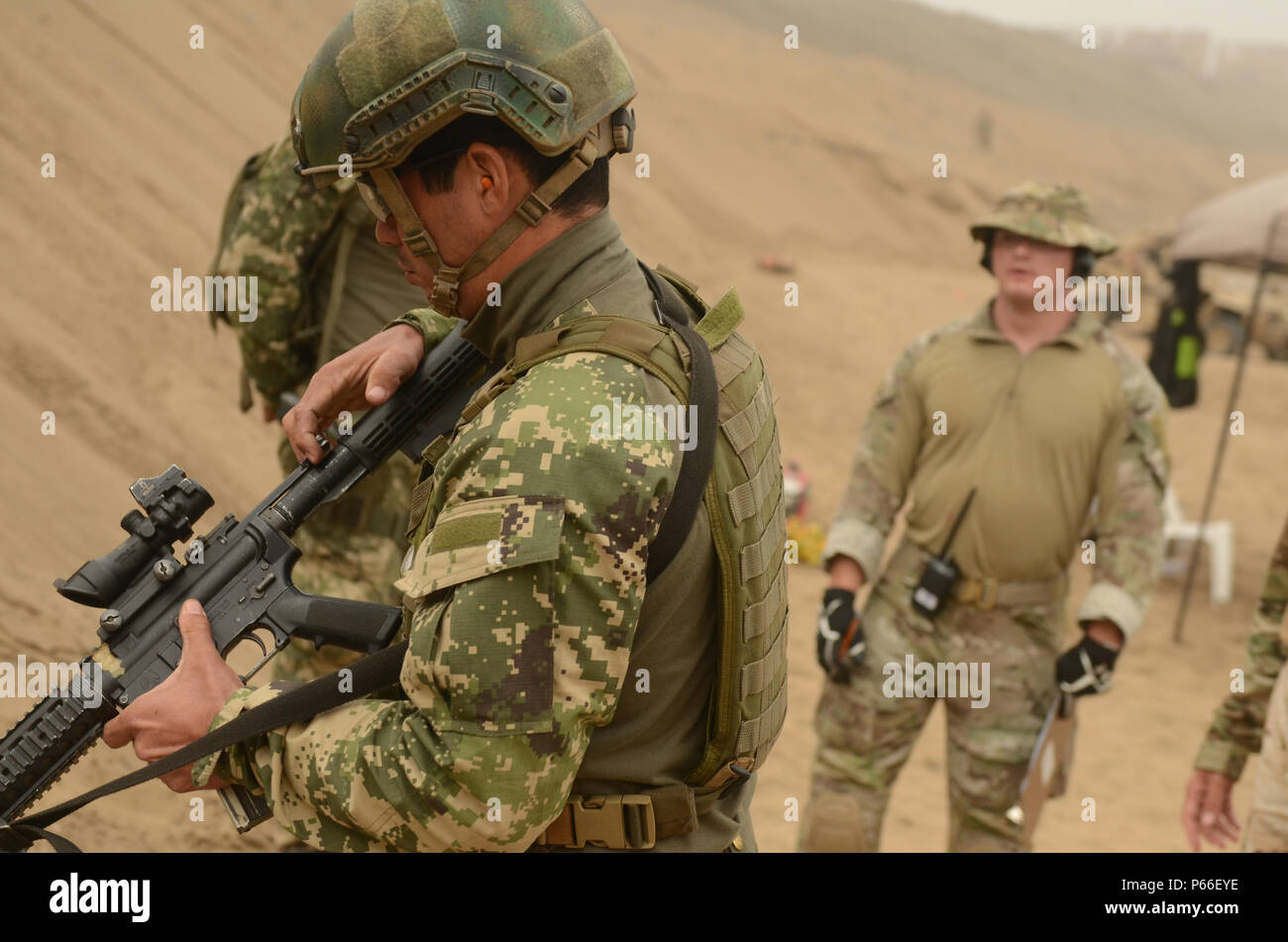 A member of Team Paraguay loads his rifle as an American soldier ...