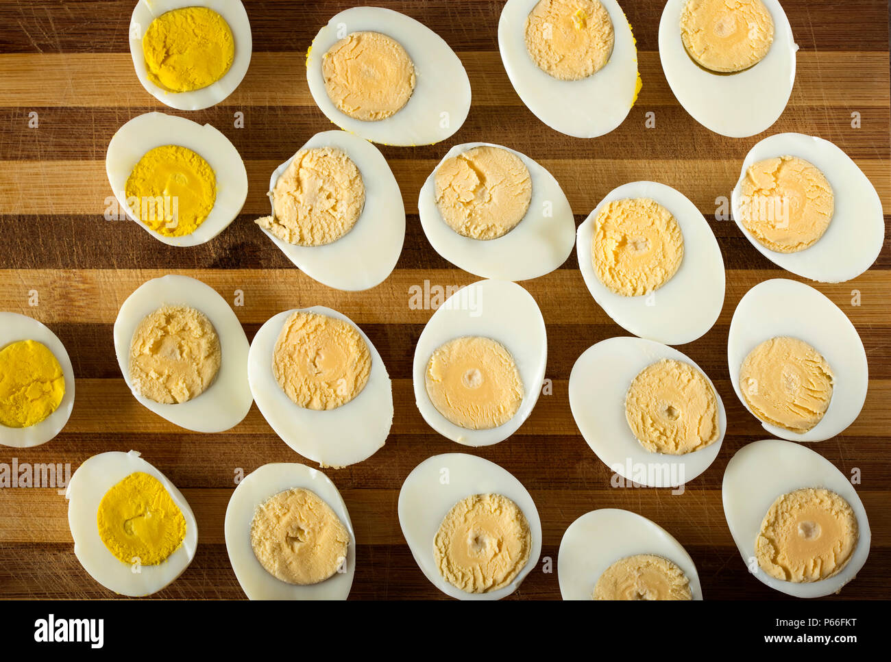 Slices of boiled hard eggs on a wooden cutting board - top view Stock ...