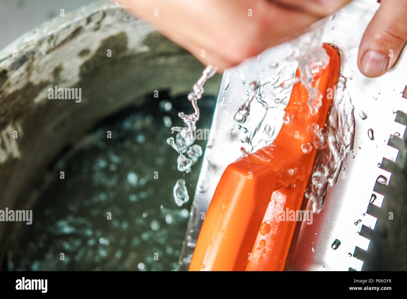 Construction Tools Cleaning Theme. Tile Trowel Washing Stock Photo - Alamy