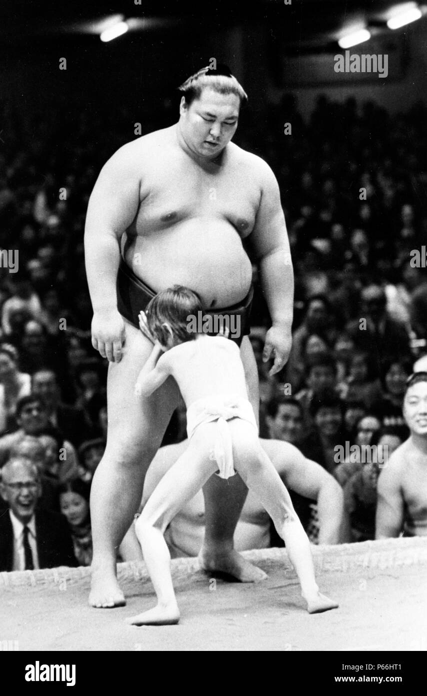 A seven-year-old Japanese boy attempts to throw champion Sumo wrestler ...
