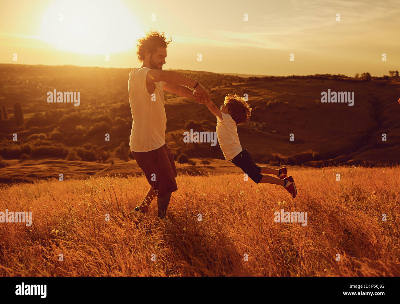 Father and child playing in nature at sunset Stock Photo - Alamy