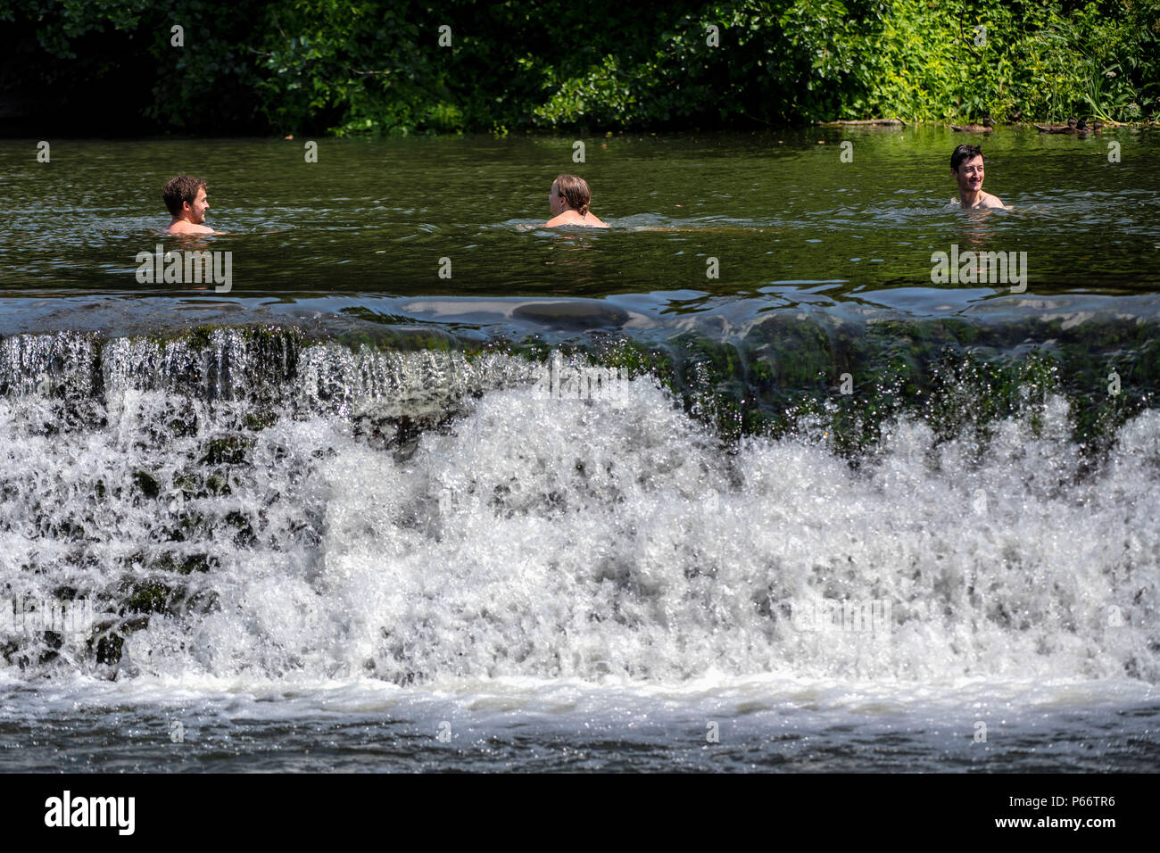 People cool down in the river Avon next to the weir at Bathampton Mill ...