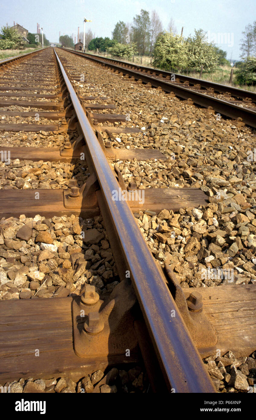 Close-up of railway track with ballast, shoes and wooden sleepers. C ...