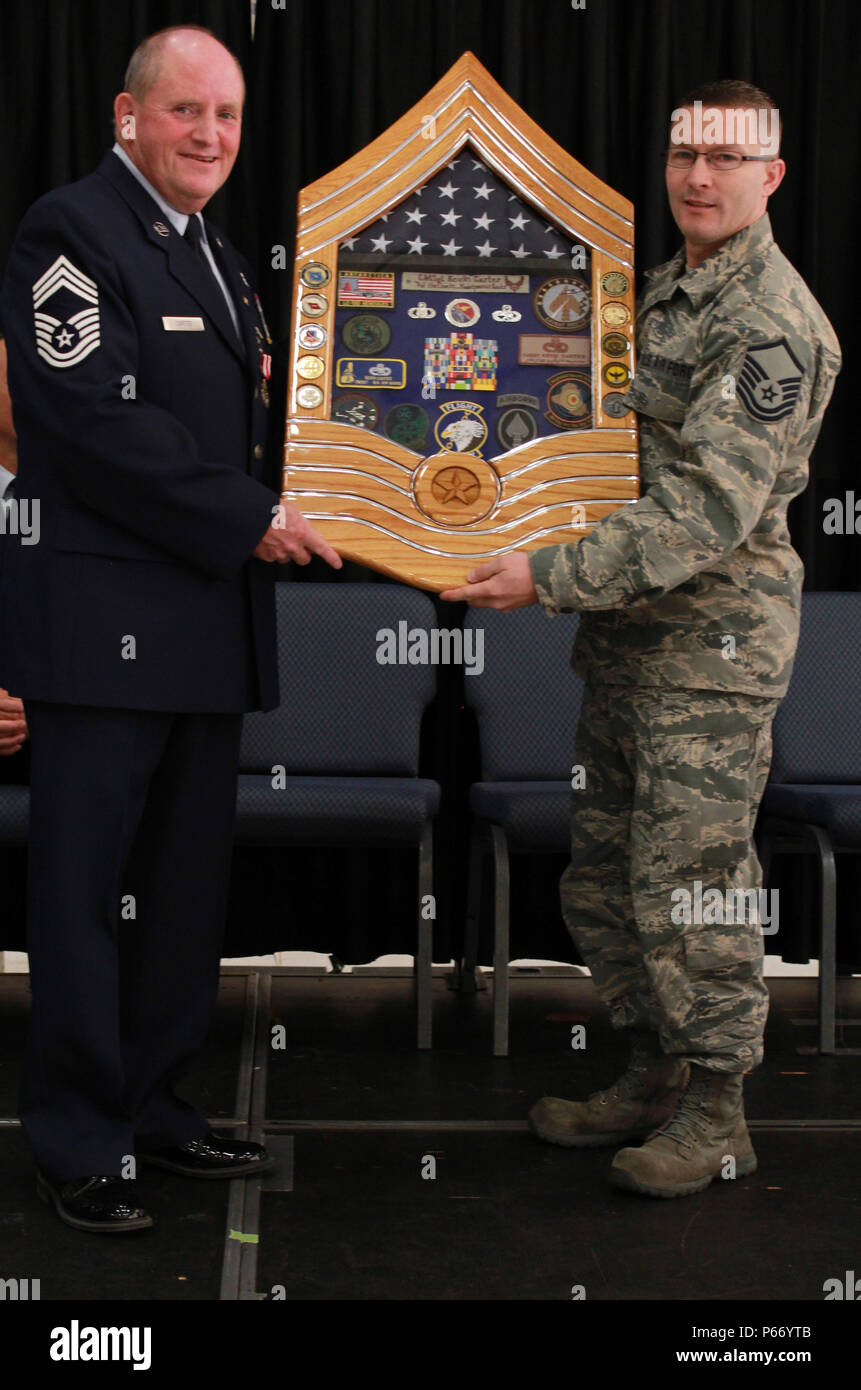 U.S. Air Force Chief Master Sgt. Kevin Carter accepts a shadow box from ...