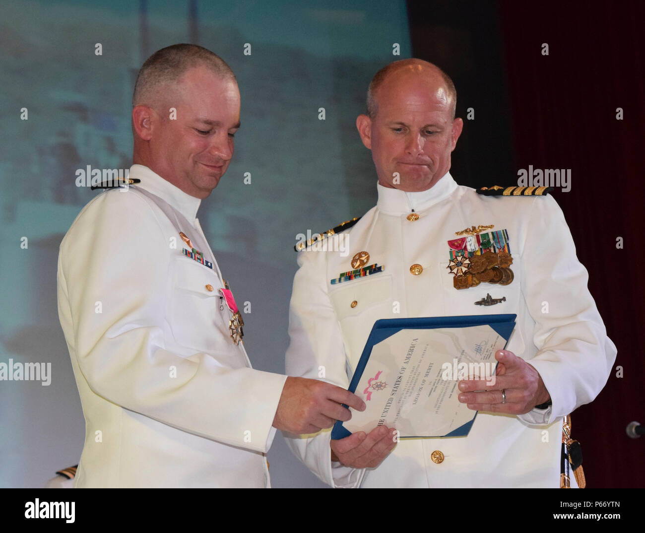 Capt. Jeffrey Grimes, right, presents Cmdr. Lance Thompson with the ...