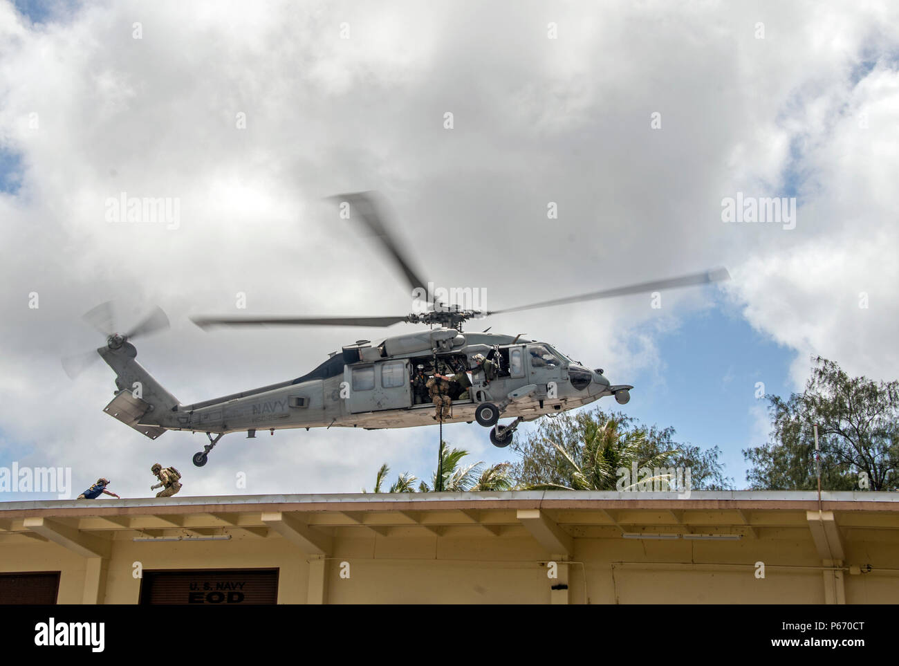 Explosive ordnance disposal technicians fast rope from a U.S. Navy MH ...