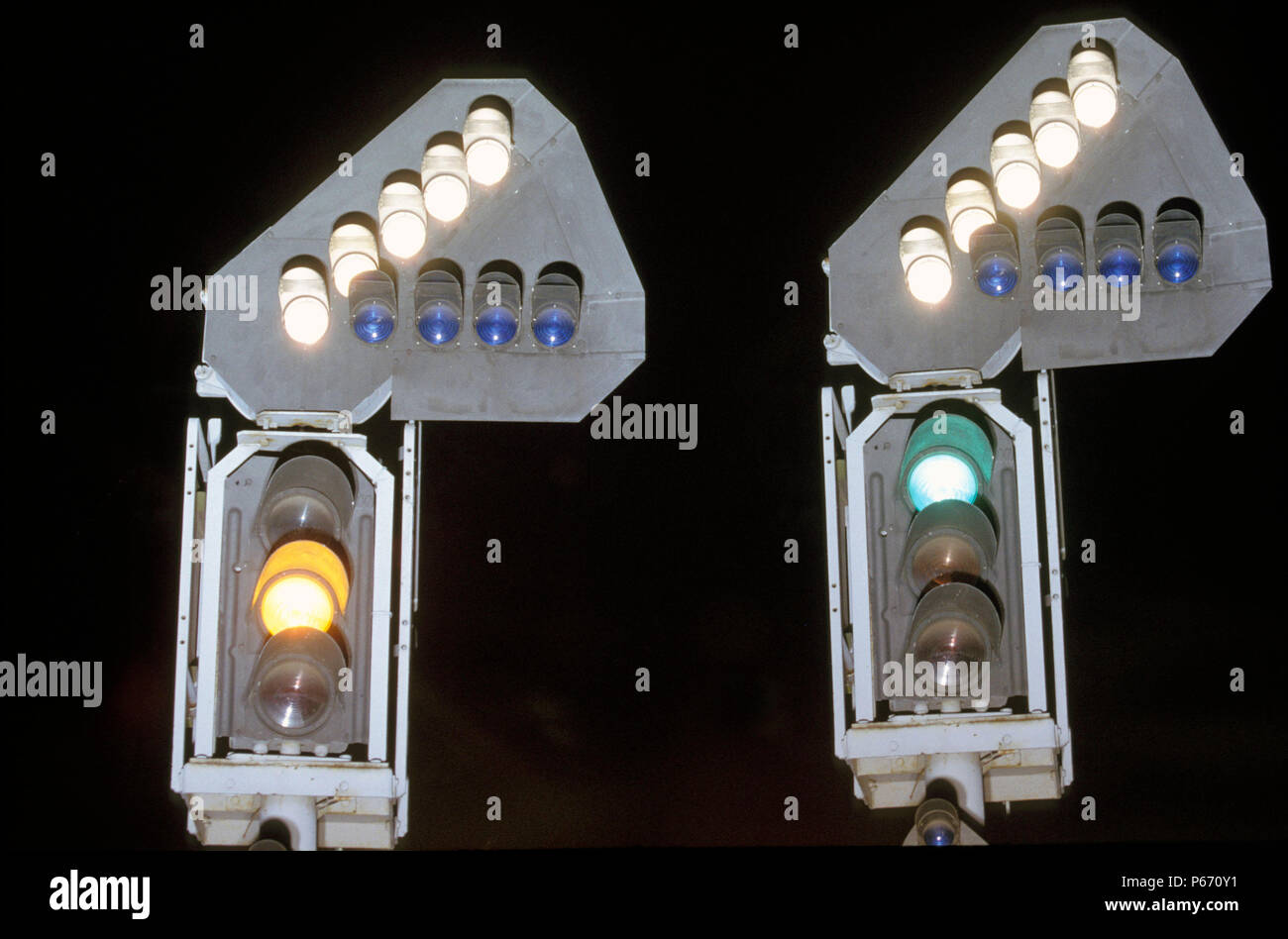 Three aspect coloured light signals one on amber, one on green, each ...