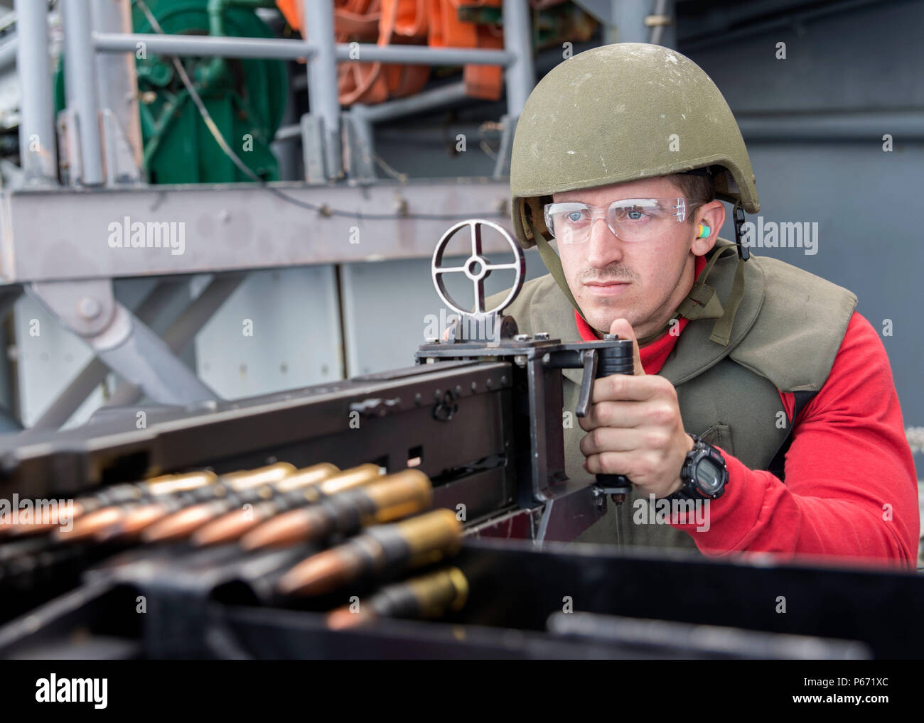 U.S. Navy Gunner's Mate Seaman Cameron Lowe aims a .50 caliber machine ...