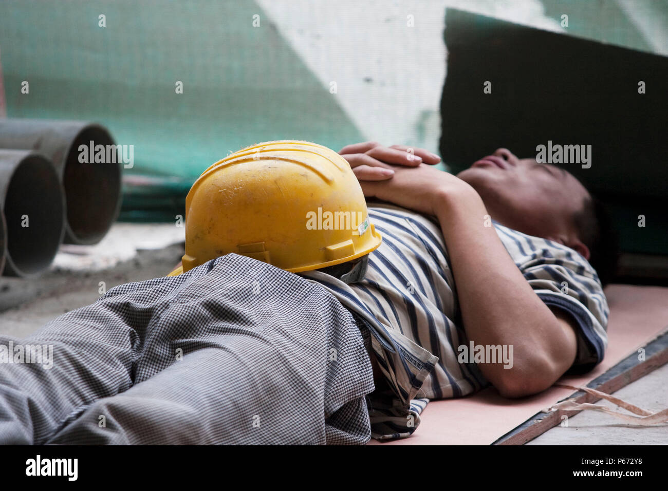 Chinese construction worker resting on site Stock Photo - Alamy