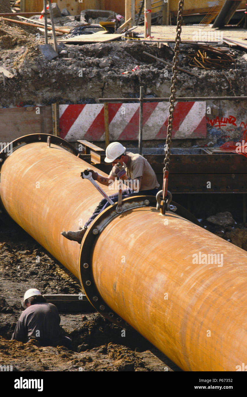 Worker securing pipe ring on large diameter steel pipe Stock Photo - Alamy