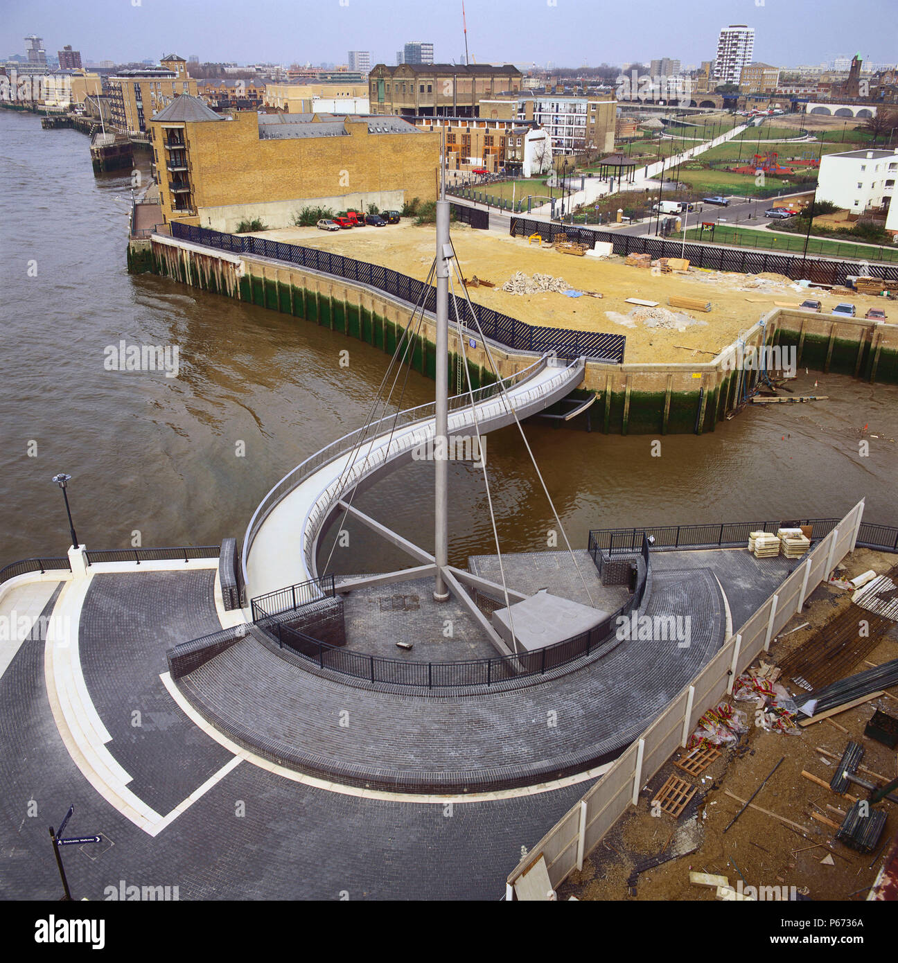 Curved footbridge over dock entrance by River Thames Docklands London ...