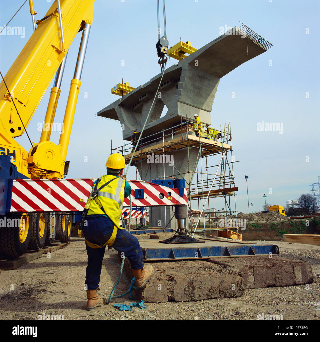 Placing box girder section on A13 viaduct London with banksman on guide ...