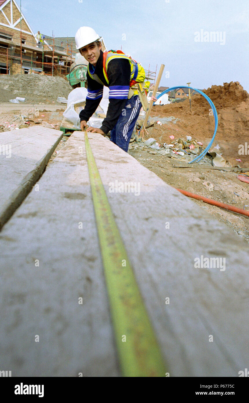 Young builder measuring timber Stock Photo - Alamy