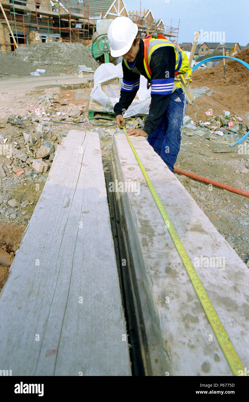 Young builder measuring timber Stock Photo - Alamy