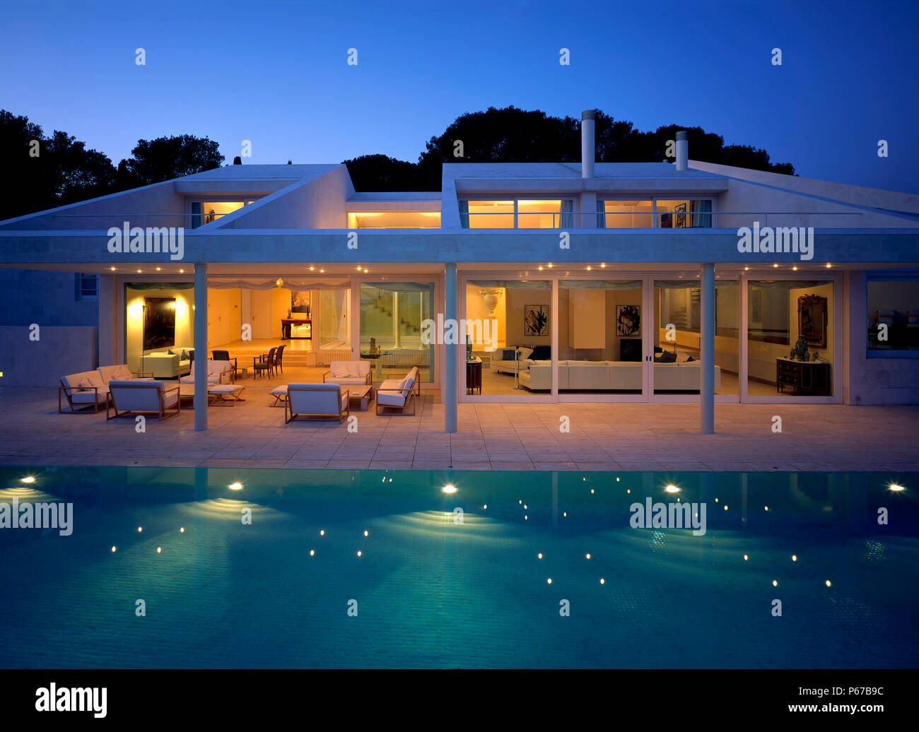 View of a lit house with a swimming pool Stock Photo - Alamy