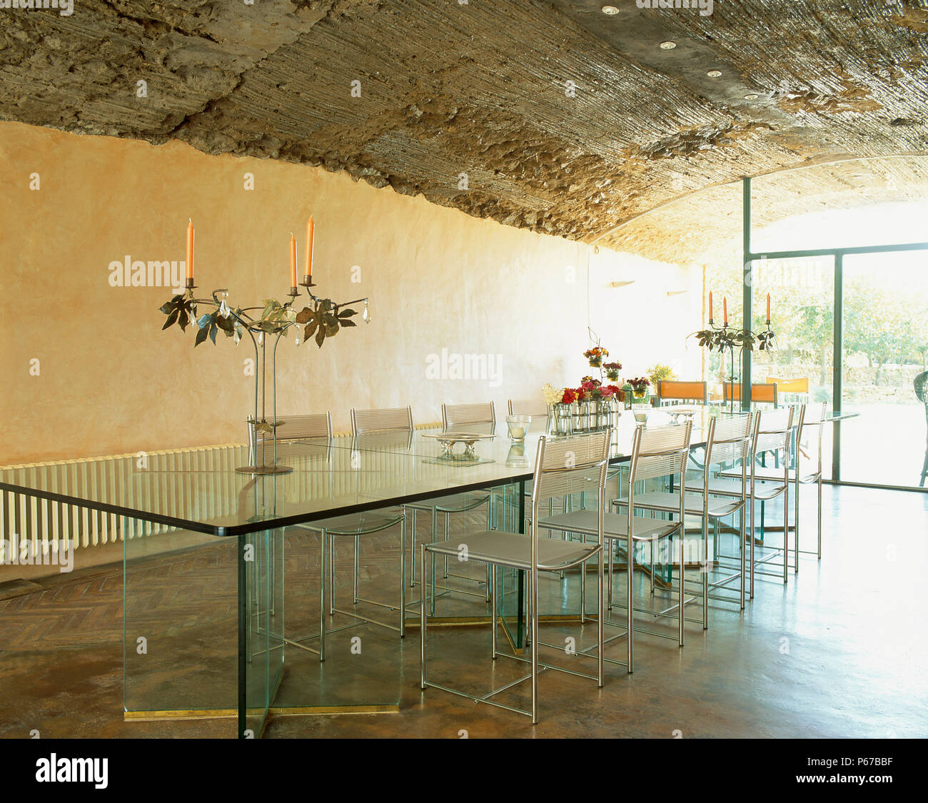 View of a long glass table set with chairs Stock Photo - Alamy