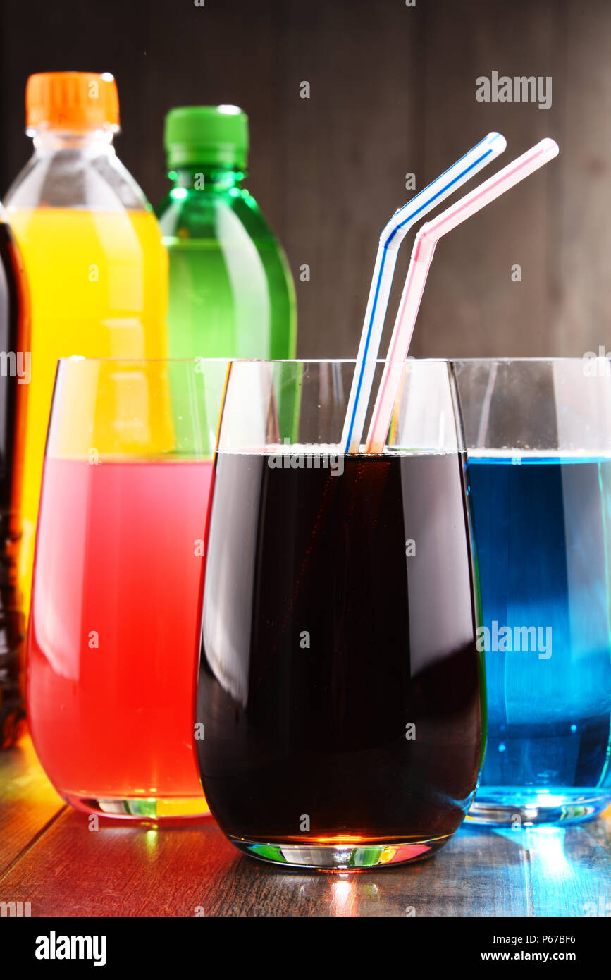 Glasses and bottles of assorted carbonated soft drinks in variety of ...