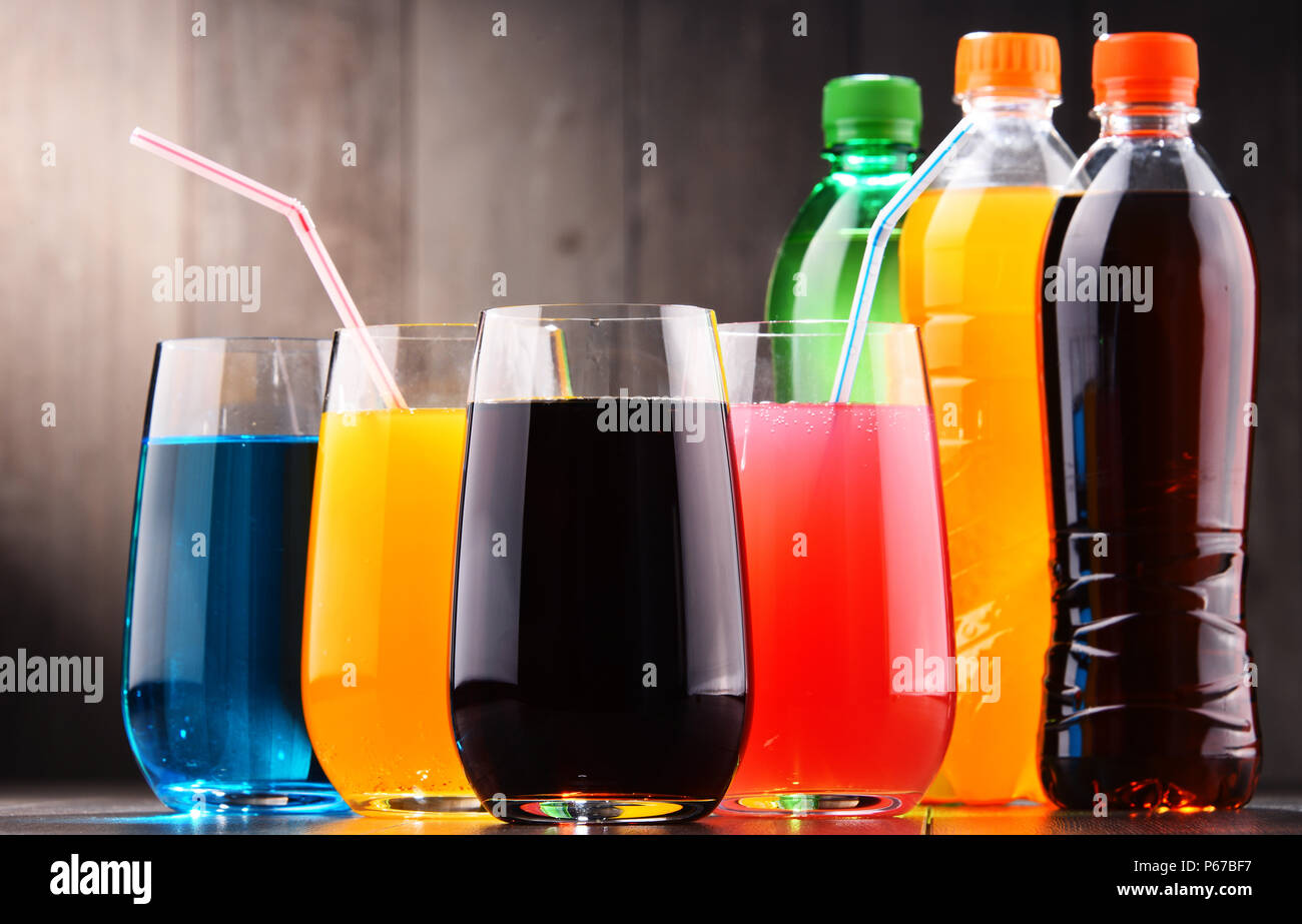 Glasses and bottles of assorted carbonated soft drinks in variety of ...