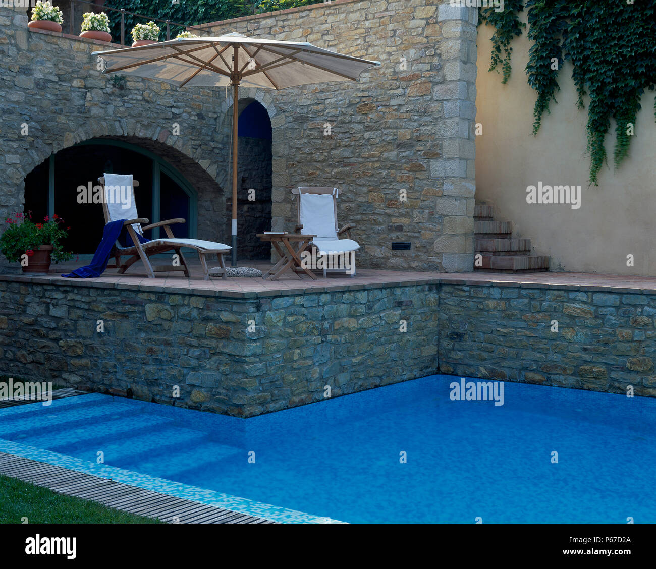 View of deck chairs near a swimming pool Stock Photo - Alamy