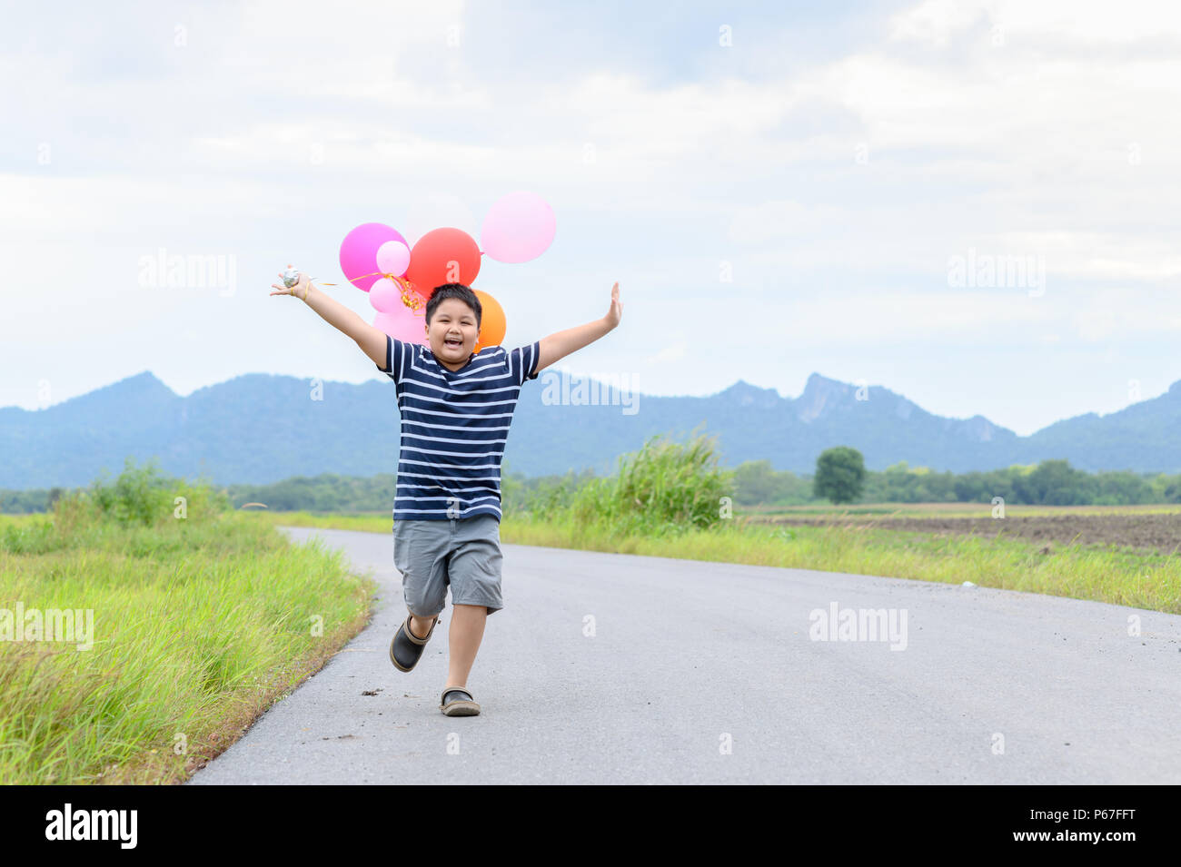 Happy fat boy running with balloon on the road, Lifestyle and leisure ...