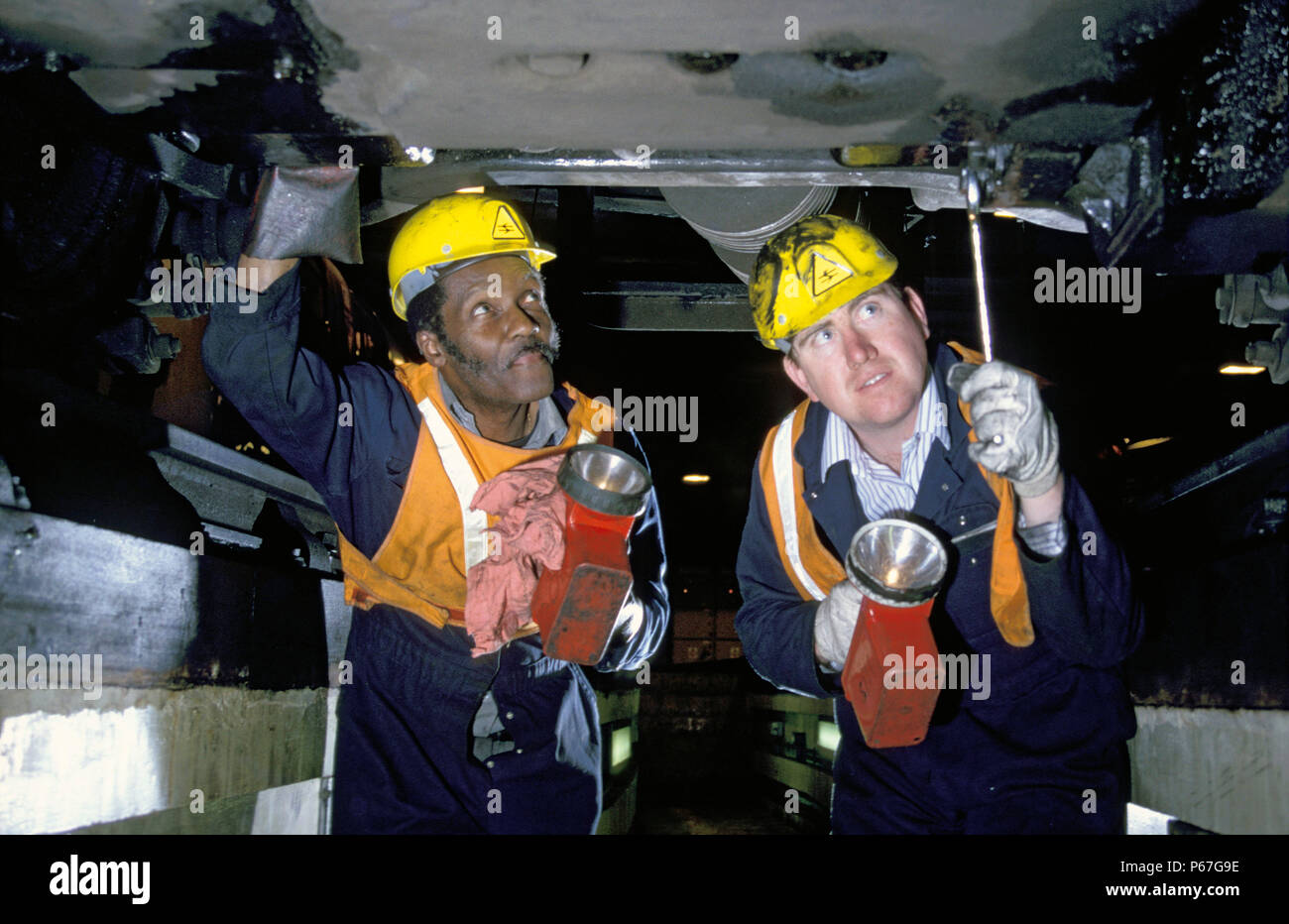 Inspecting the underside of a train from the inspection pit in the ...
