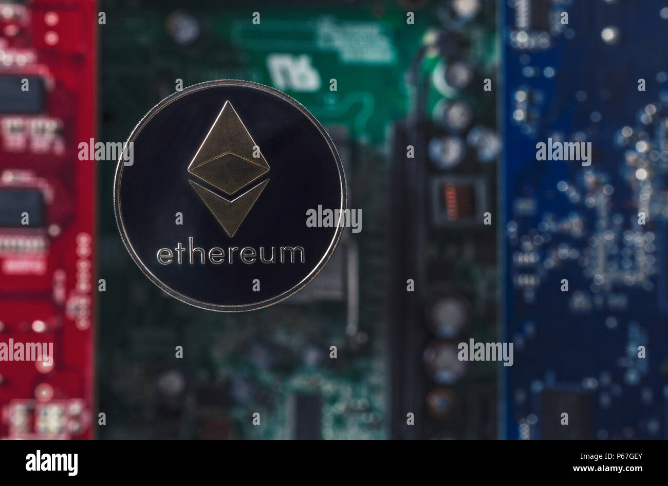 Dark Ethereum coin on blurry background of electronical components as ...