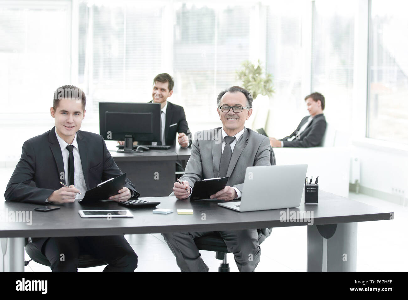business colleagues sitting at a Desk in the office Stock Photo - Alamy