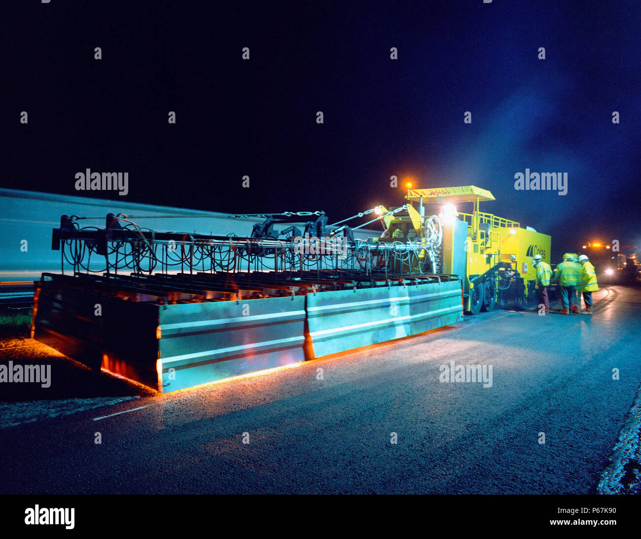 Road surfacing in progress with an asphalt spreader laying heated ...
