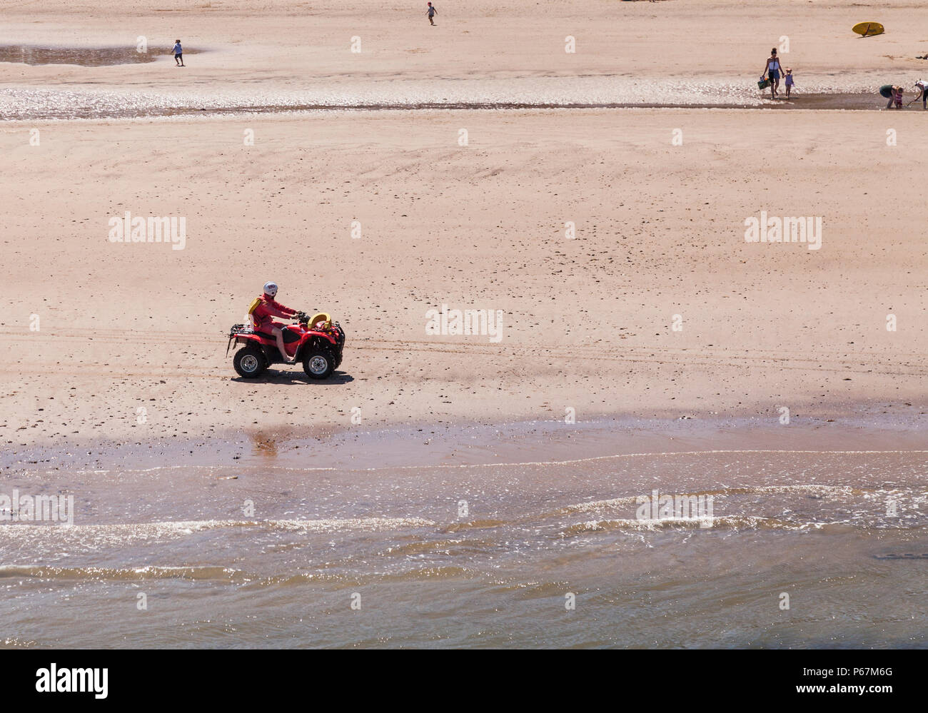 Life guard patrolling the beach on a quad bike at Saltburn by the Sea ...