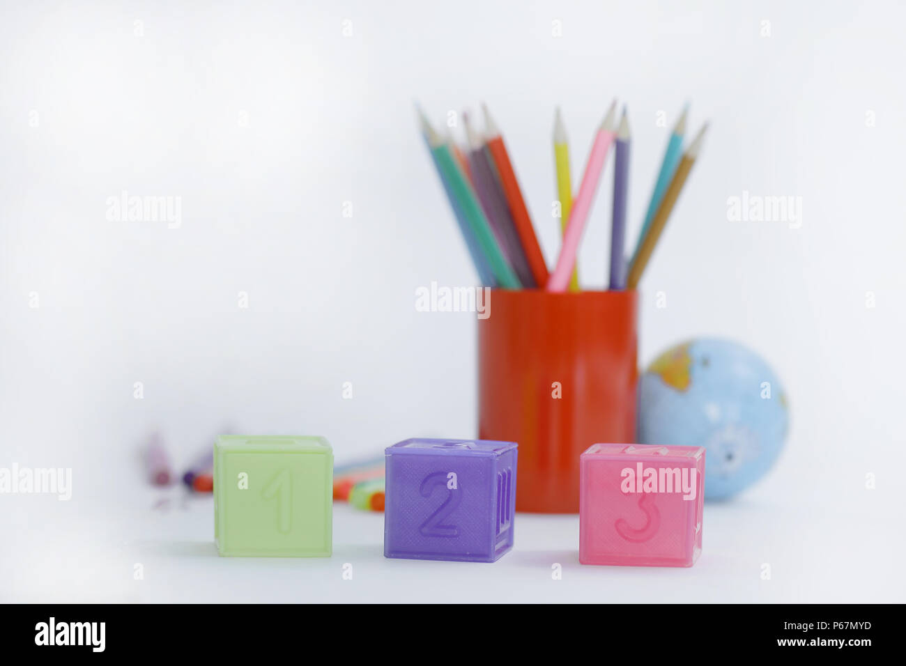 cubes with numbers on blurred school supplies background Stock Photo ...