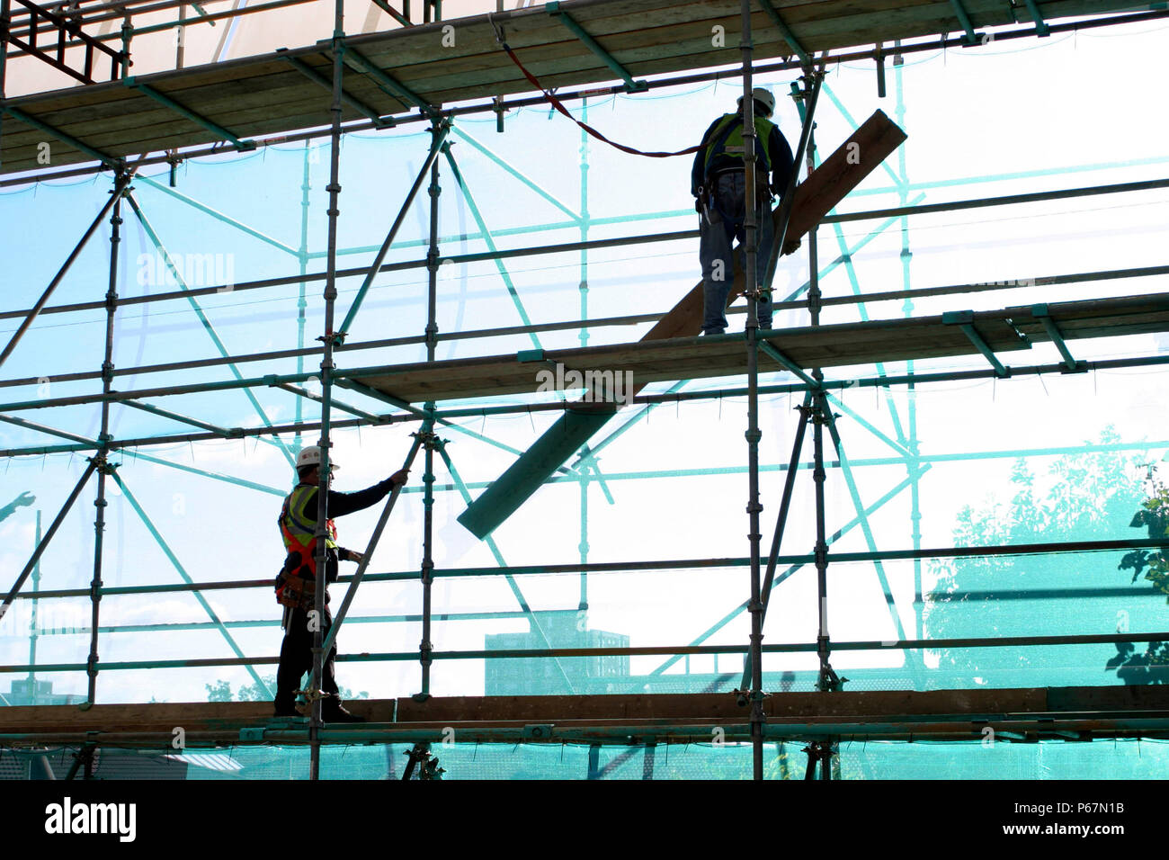 Scaffolder erecting a scaffolding Stock Photo - Alamy