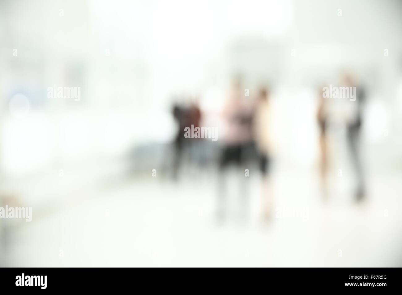 blurred image of a group of business people talking in the office lobby ...