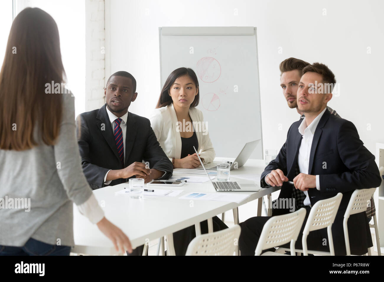 Diverse team being judgmental scolding unpunctual colleague Stock Photo ...