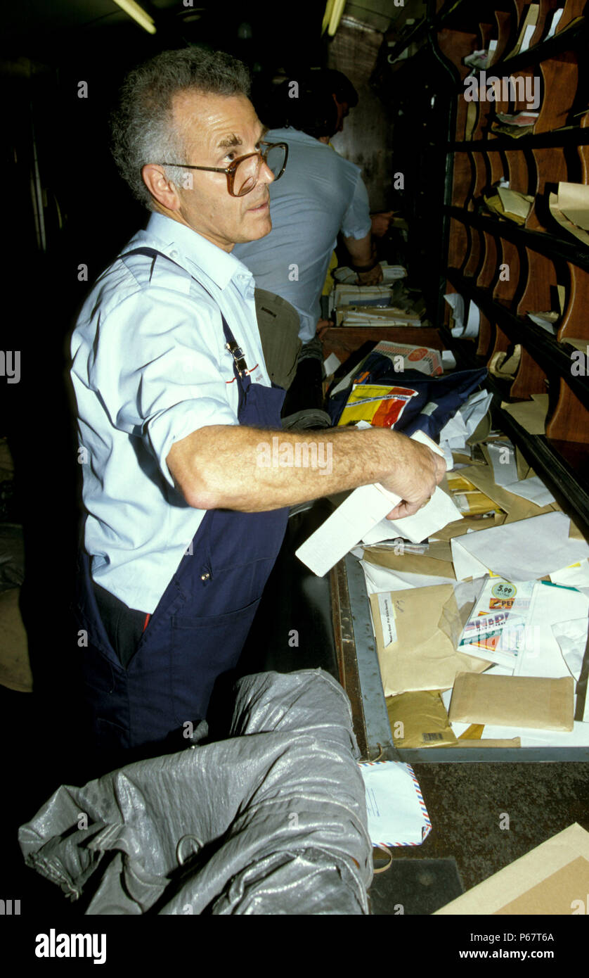 Postal worker sorts mail on the overnight Travelling Post Office. C1993 ...
