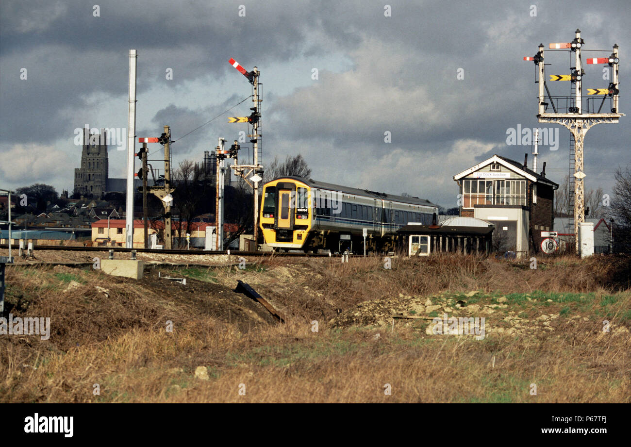 Semaphore signals at Ely Dock Junction as a Class 158 DMU passes with ...