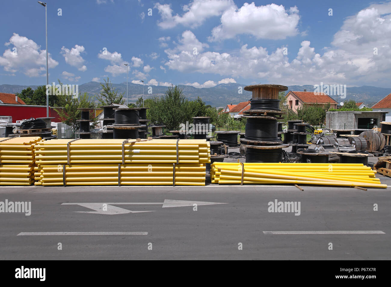 Construction pipes and cable reels at open storage Stock Photo - Alamy