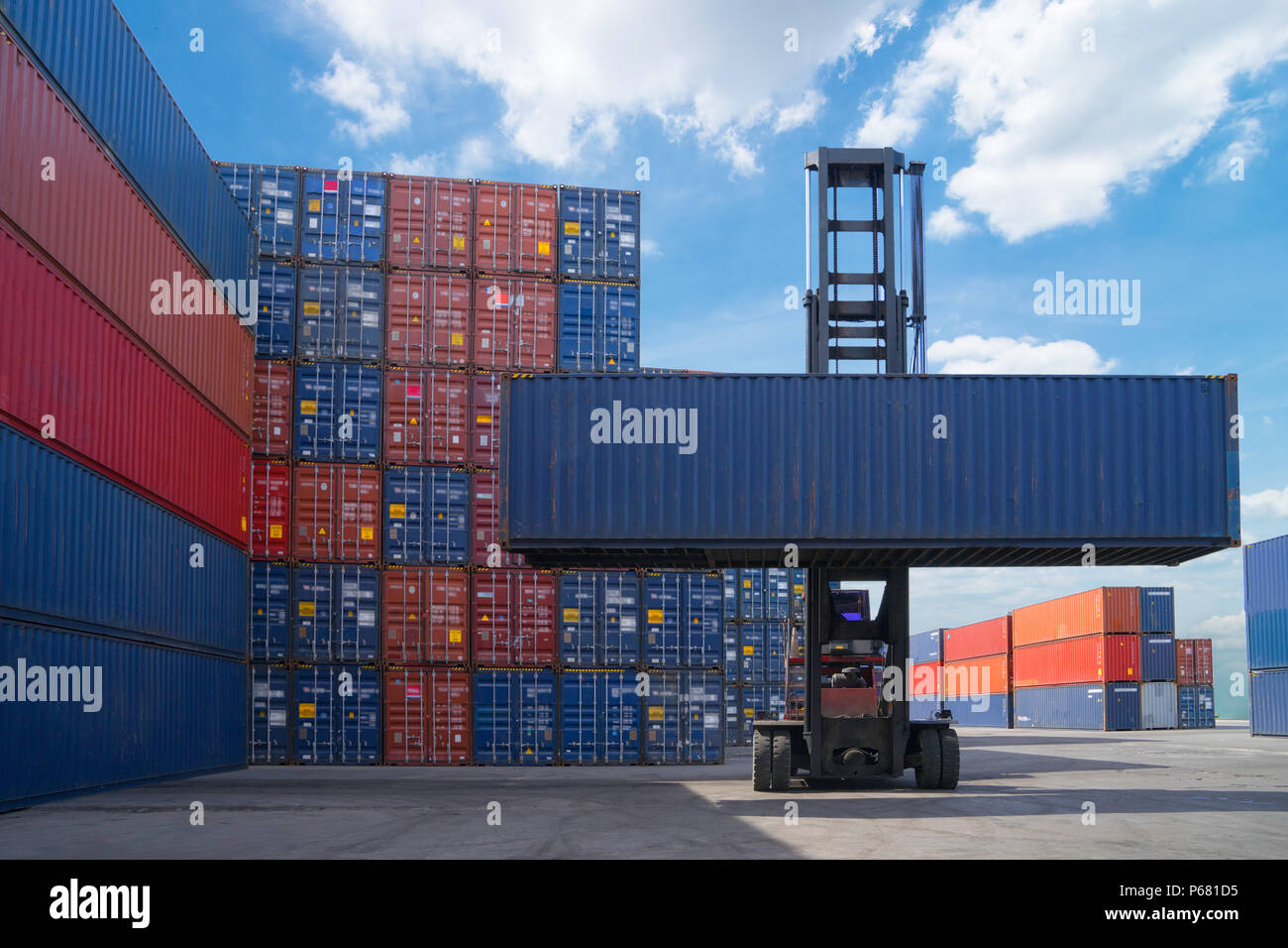 Forklift truck lifting cargo container in shipping yard or dock yard ...
