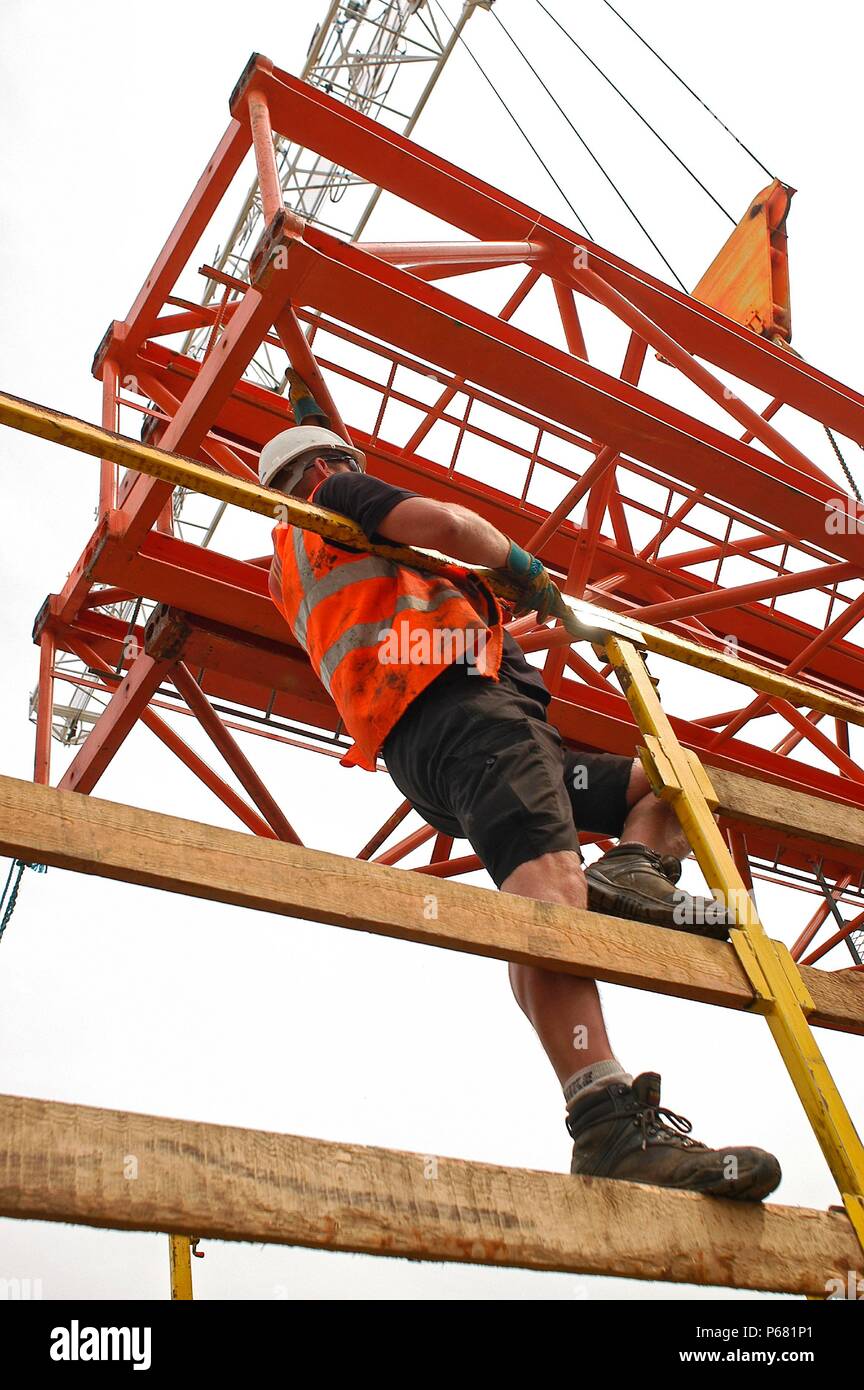 "Banksmen unloading crane from truck on construction site, London, UK ...