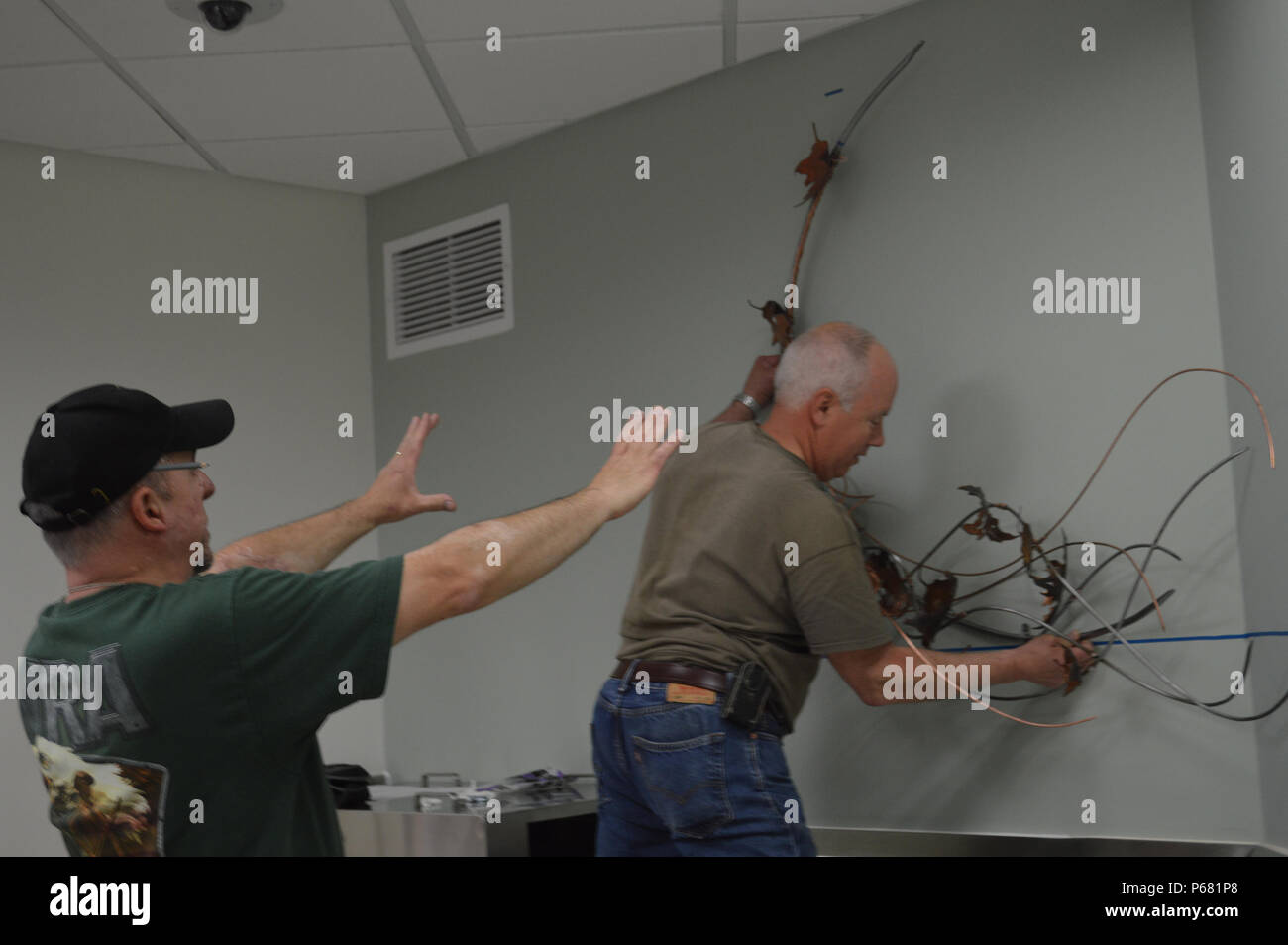 Bill Kleinedler and his father-in-law John Tripp hang the new sculpture ...