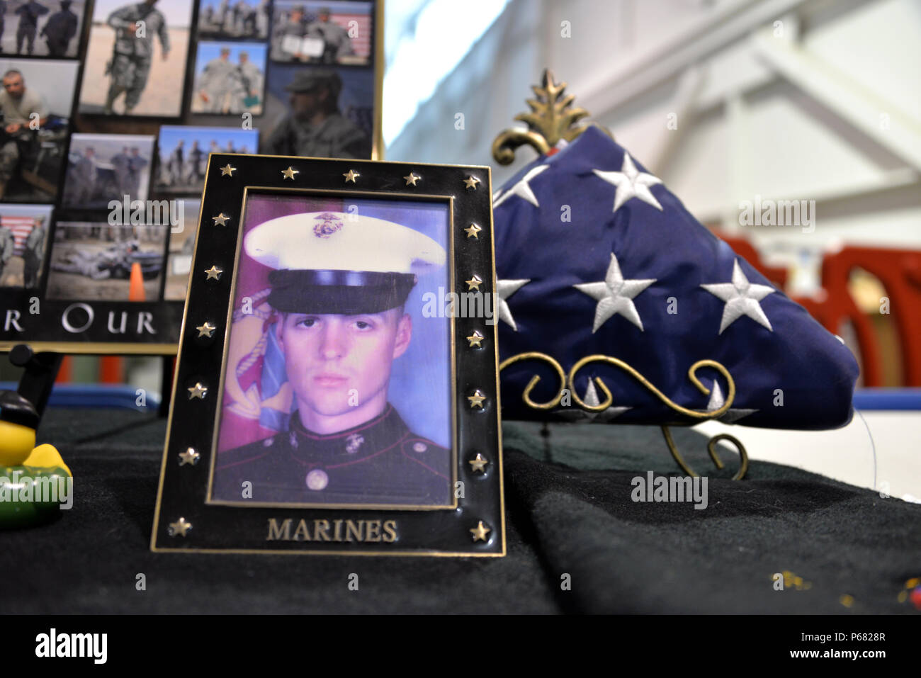 A picture of a fallen service member sits on one of several display ...