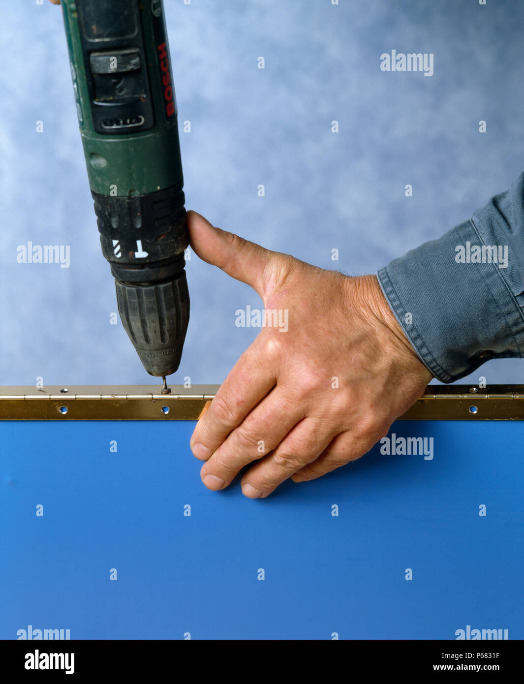 Close-up of hands using electric screwdriver FOR EDITORIAL USE ONLY ...