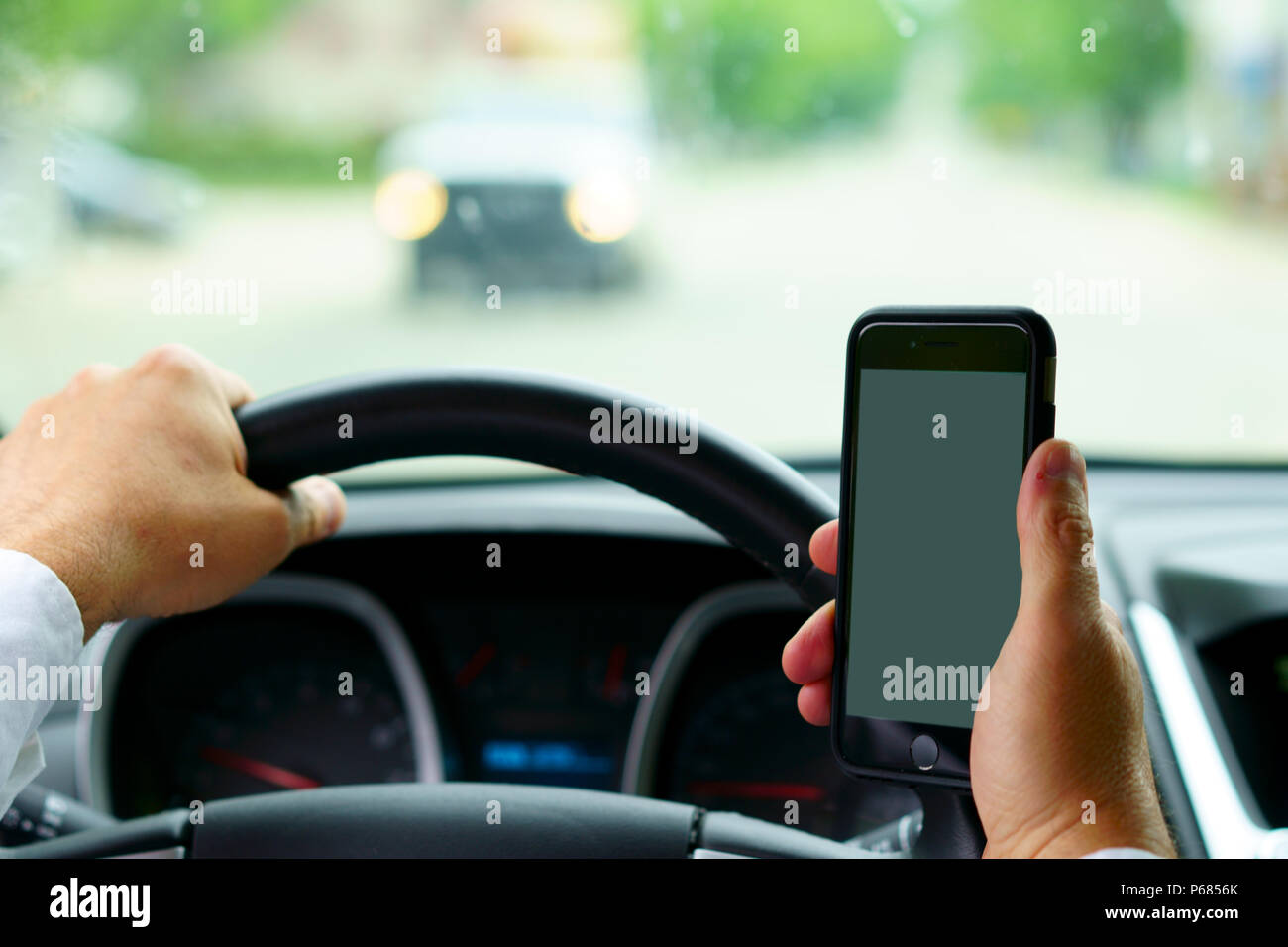 Don't text and drive! A man is texting with a finger while a car is ...