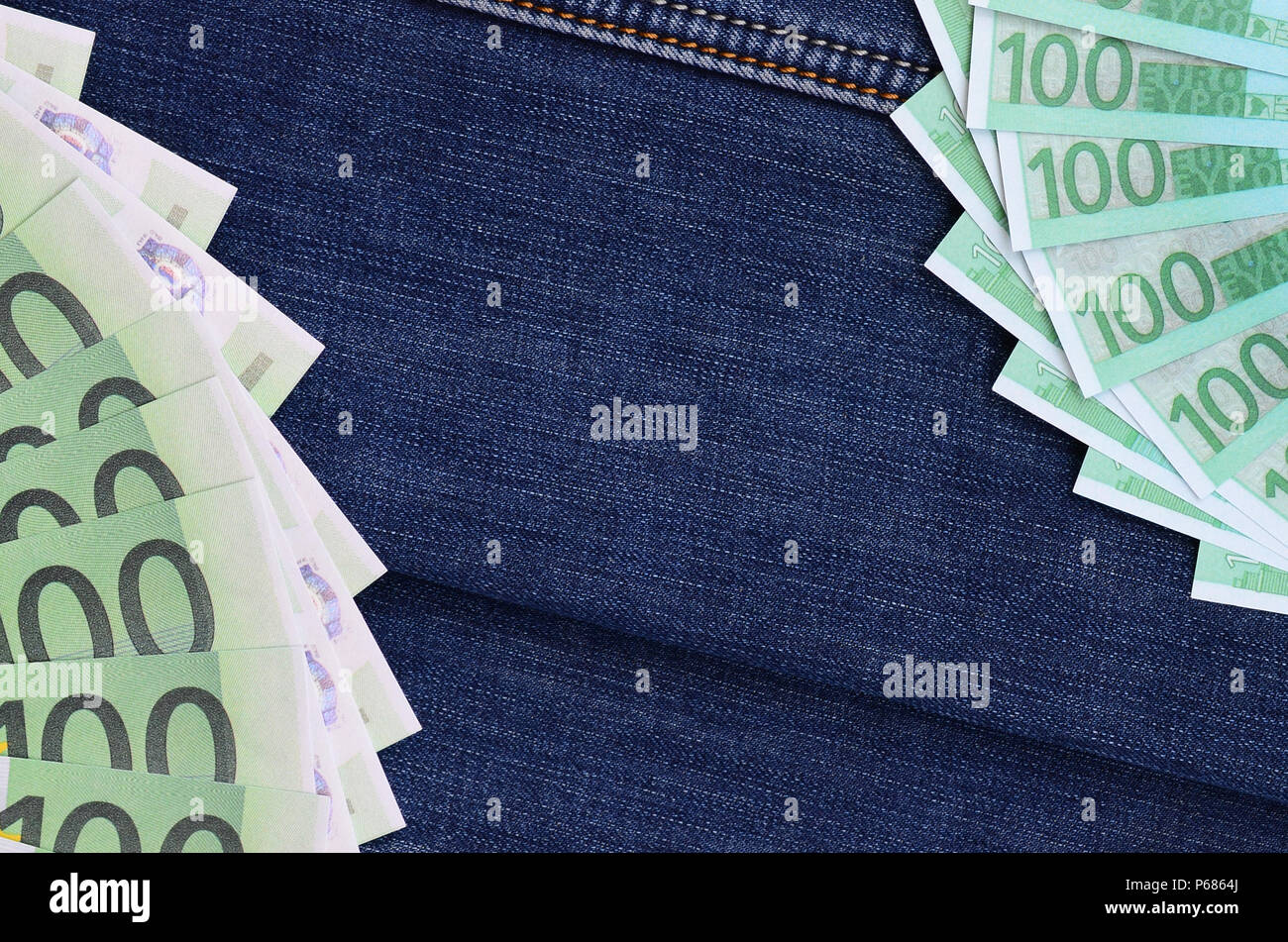 The fan of a lot of euro bills is on a dark denim surface. Background ...
