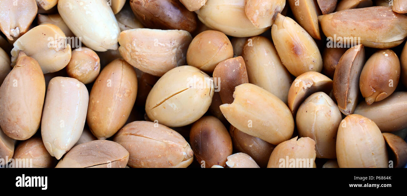 Peanut. A lot of small yellow nuts without peel. Background texture ...
