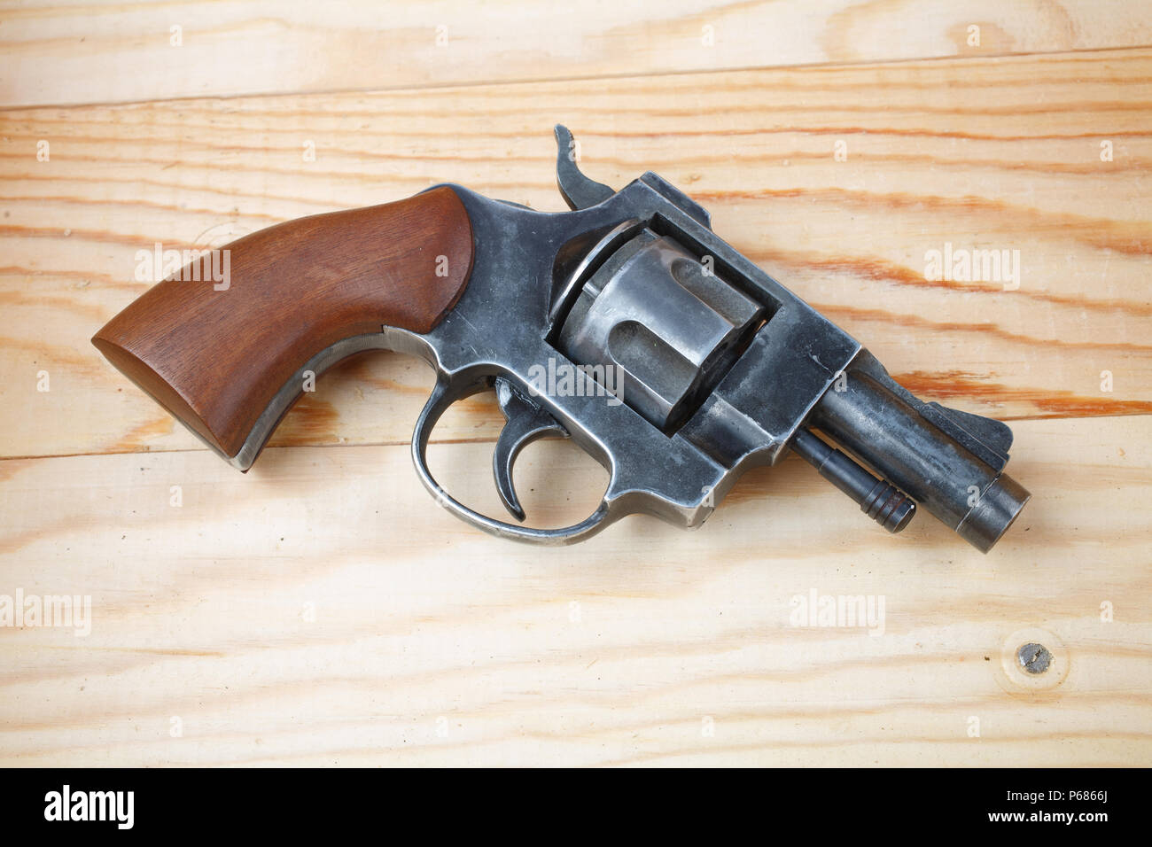 Revolver on the wooden table background Stock Photo - Alamy